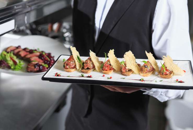 Waiter holding serving plate of food